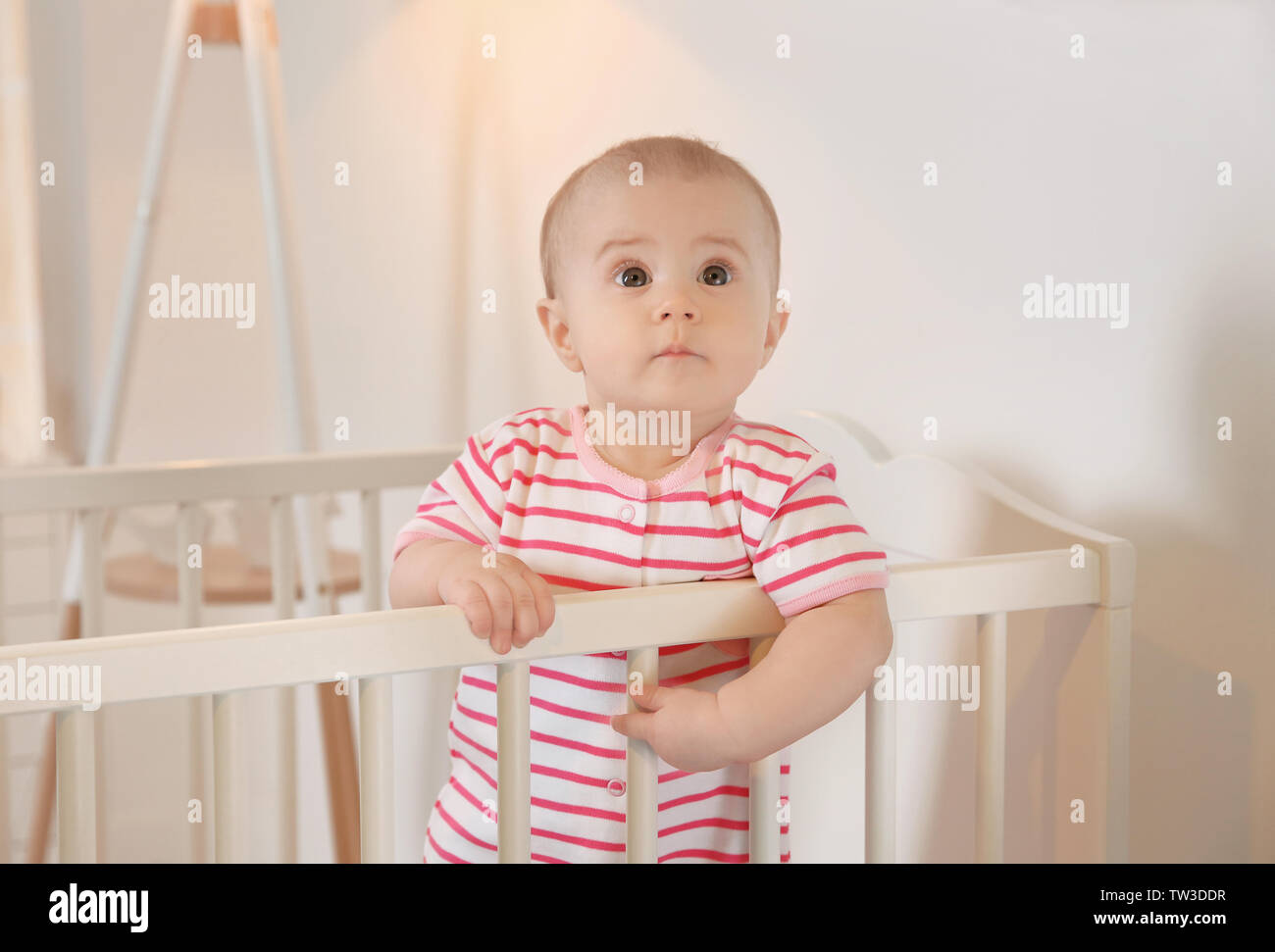Cute little baby standing in crib at home Stock Photo - Alamy