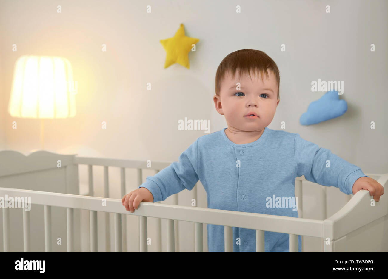 Cute little baby standing in crib at home Stock Photo - Alamy