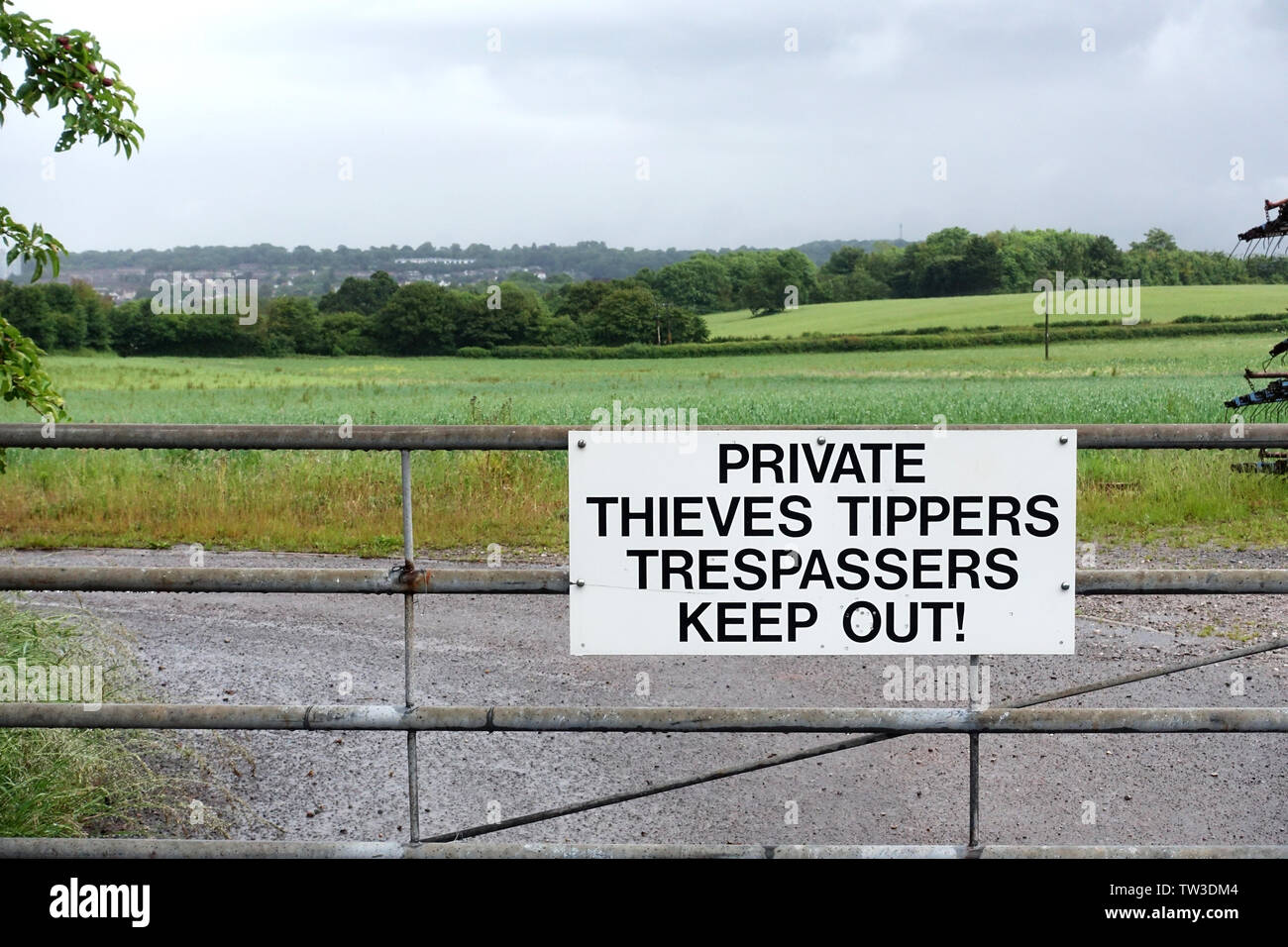 A warning notice on a farm gate into a field warning trespassers ...