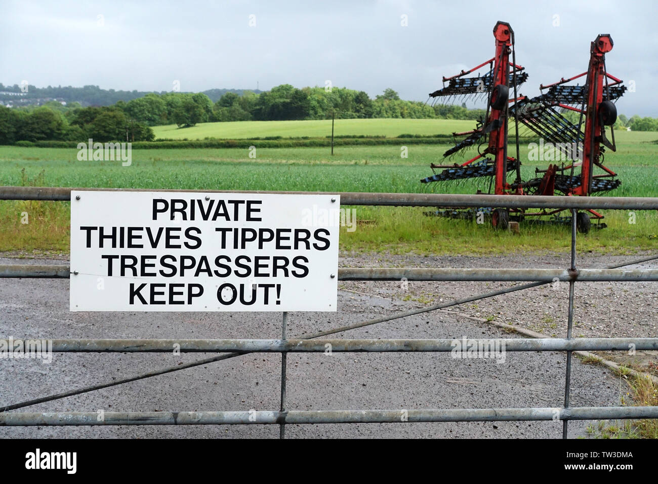 A warning notice on a farm gate into a field warning trespassers ...