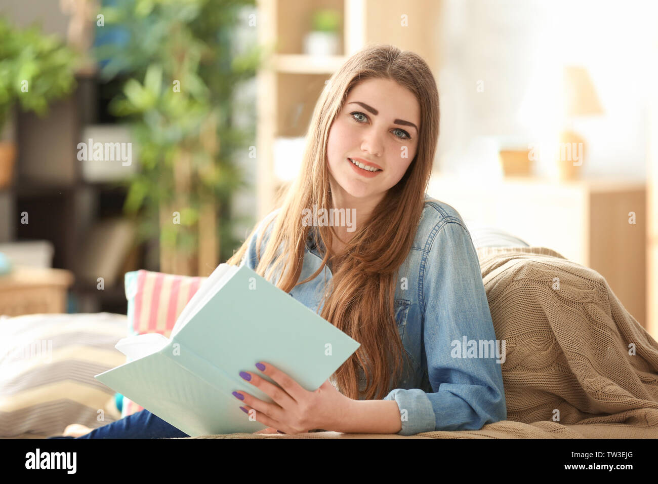 Beautiful woman reading book at home Stock Photo - Alamy