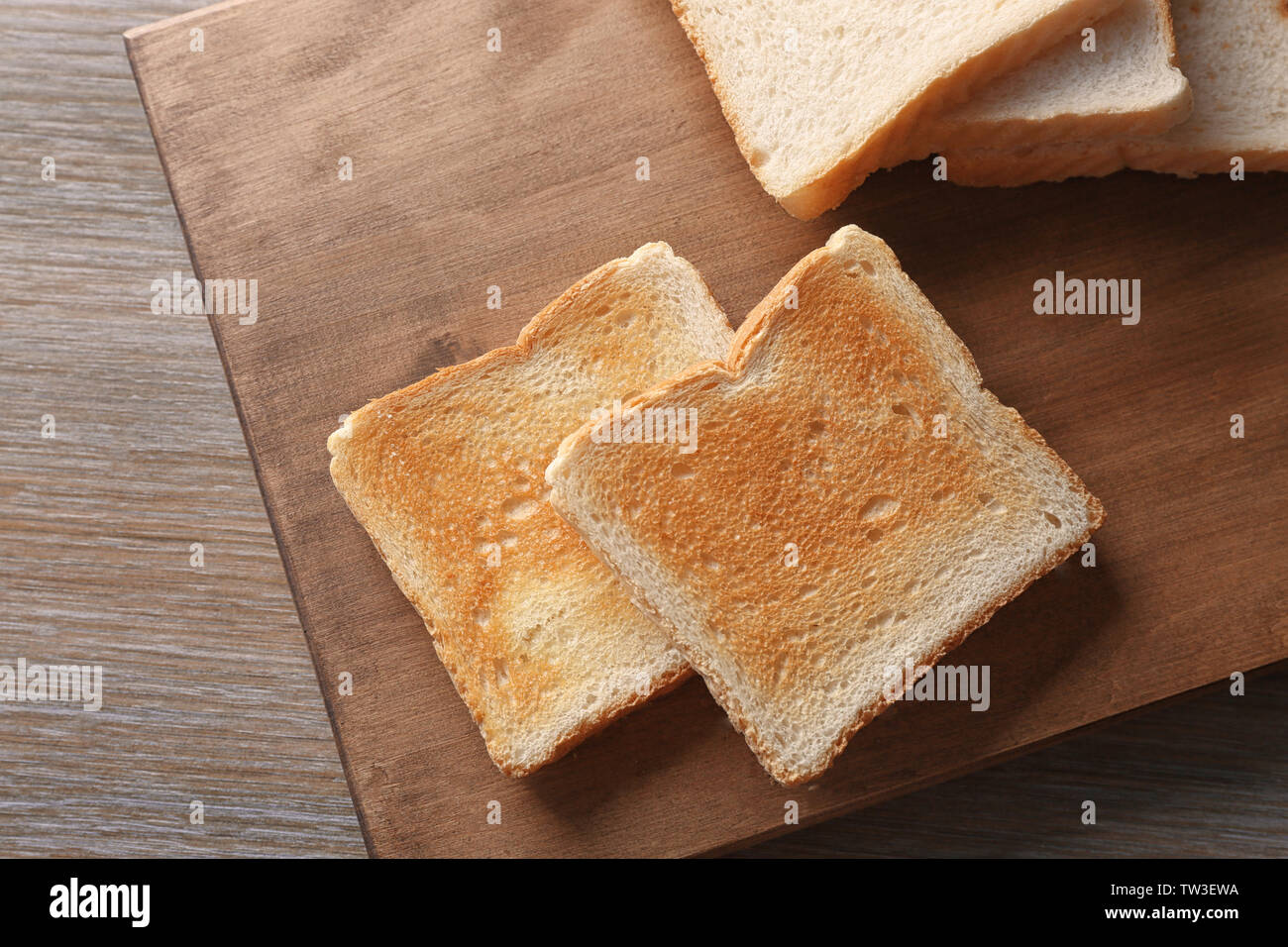 Wooden board with tasty breakfast toasts on table Stock Photo - Alamy