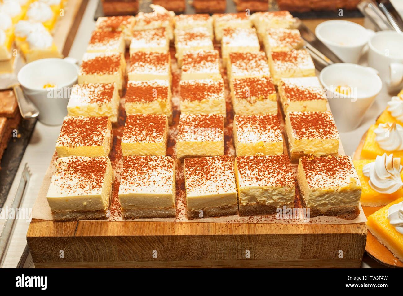Small assorted cakes lined up decorated on dessert buffet. Sweet ...