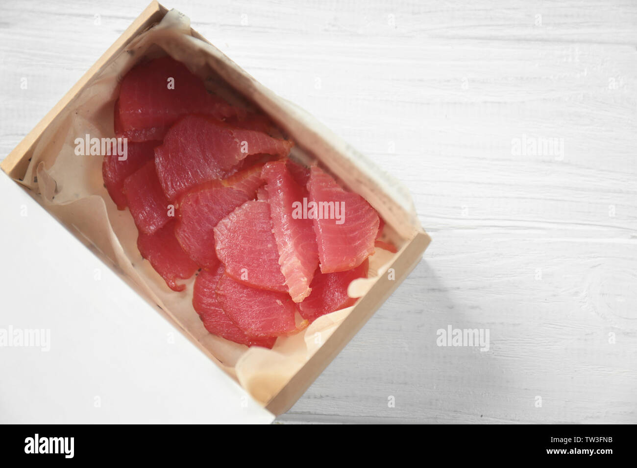 Cardboard box with delicious tuna on wooden table Stock Photo - Alamy