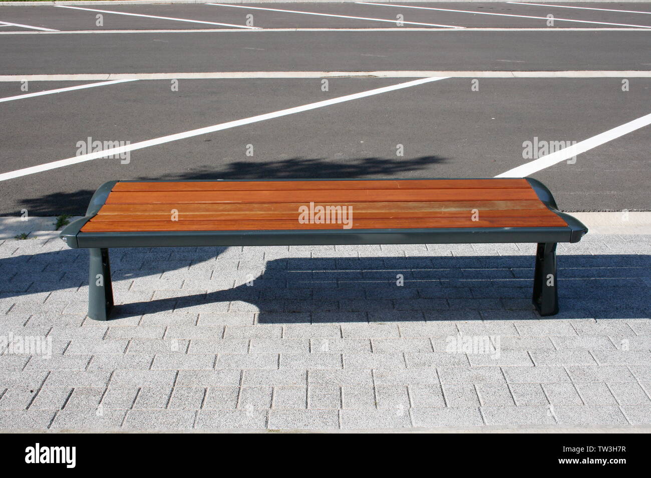 A resting bench made of wood on a parking lot Stock Photo - Alamy