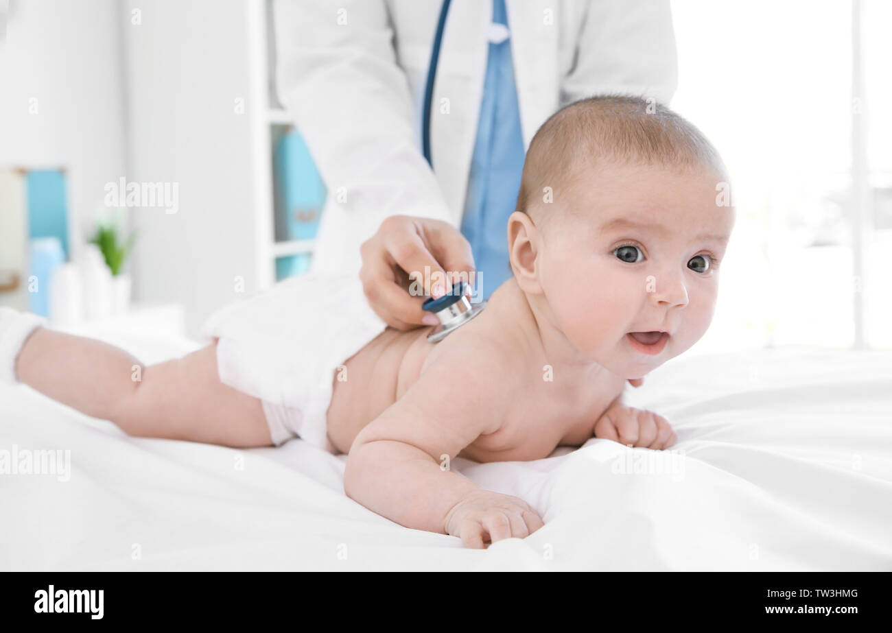 Doctor examining little baby with stethoscope in clinic. Baby health ...