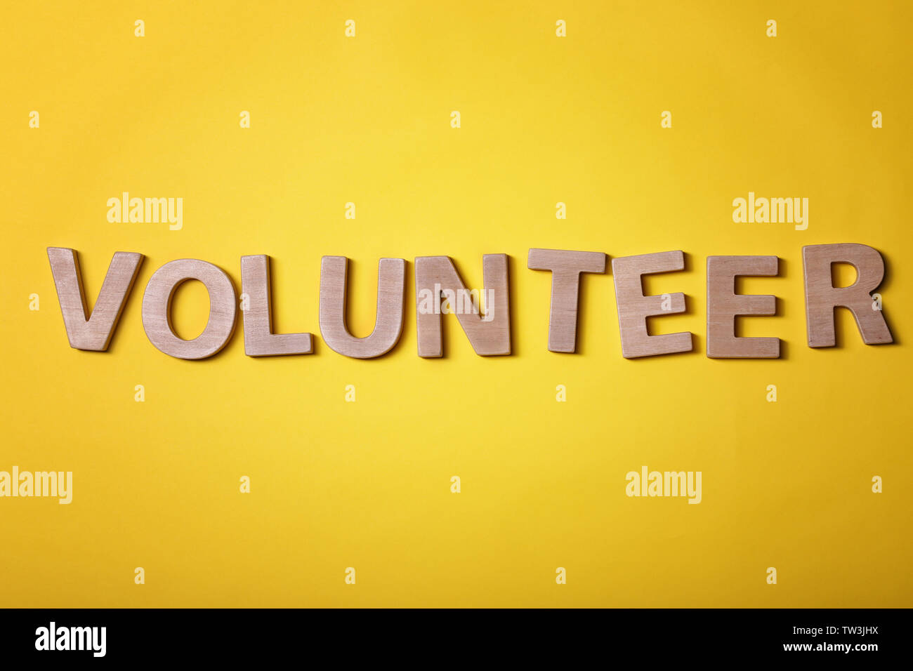 Word VOLUNTEER made of wooden letters on color background Stock Photo ...