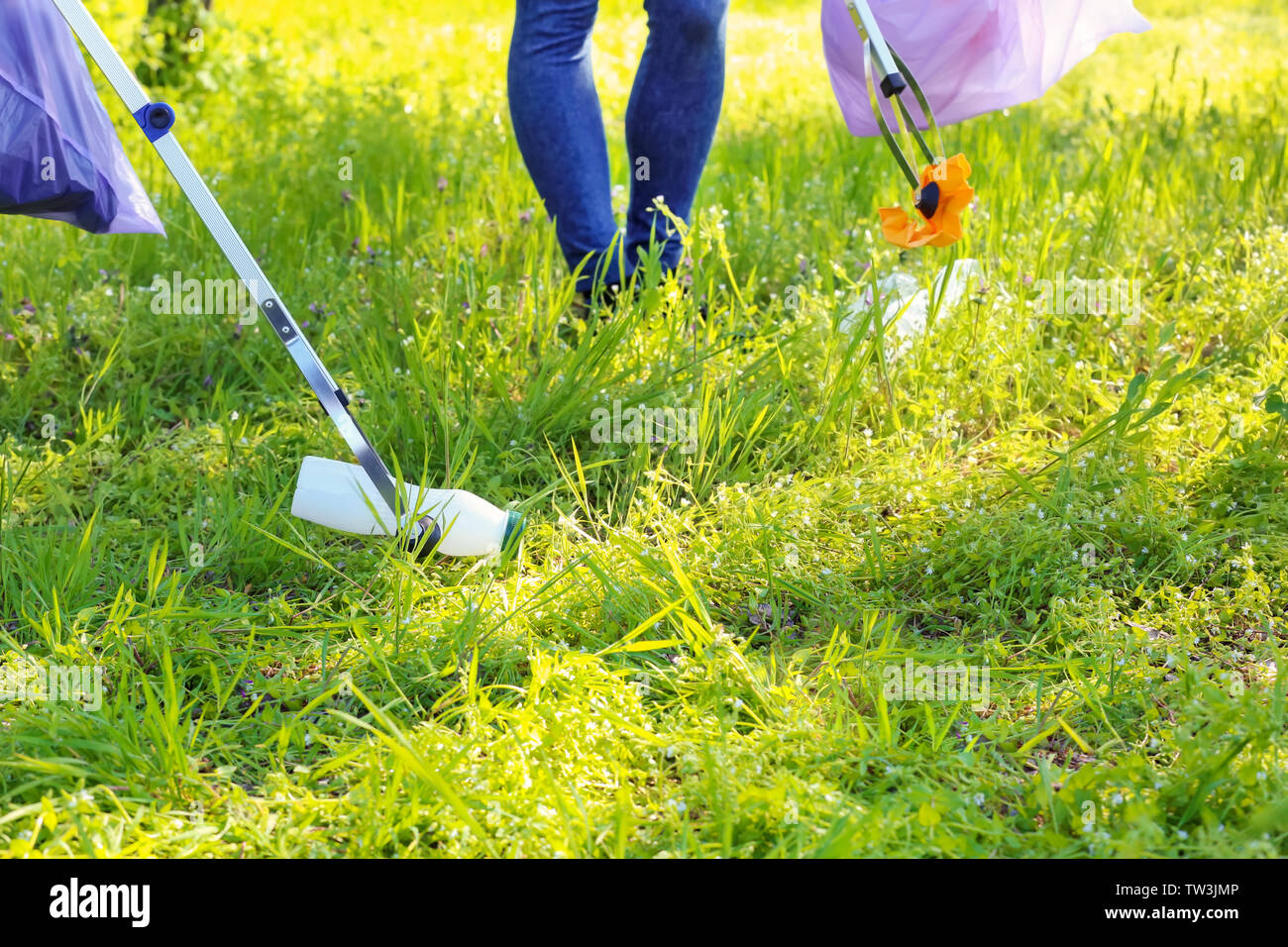 People gathering garbage with trash pickers. Volunteering concept Stock ...
