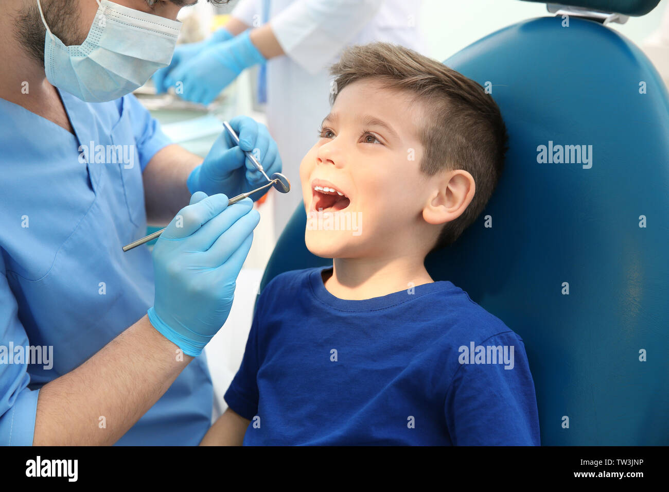 Dentist examining little boy's teeth in clinic Stock Photo - Alamy