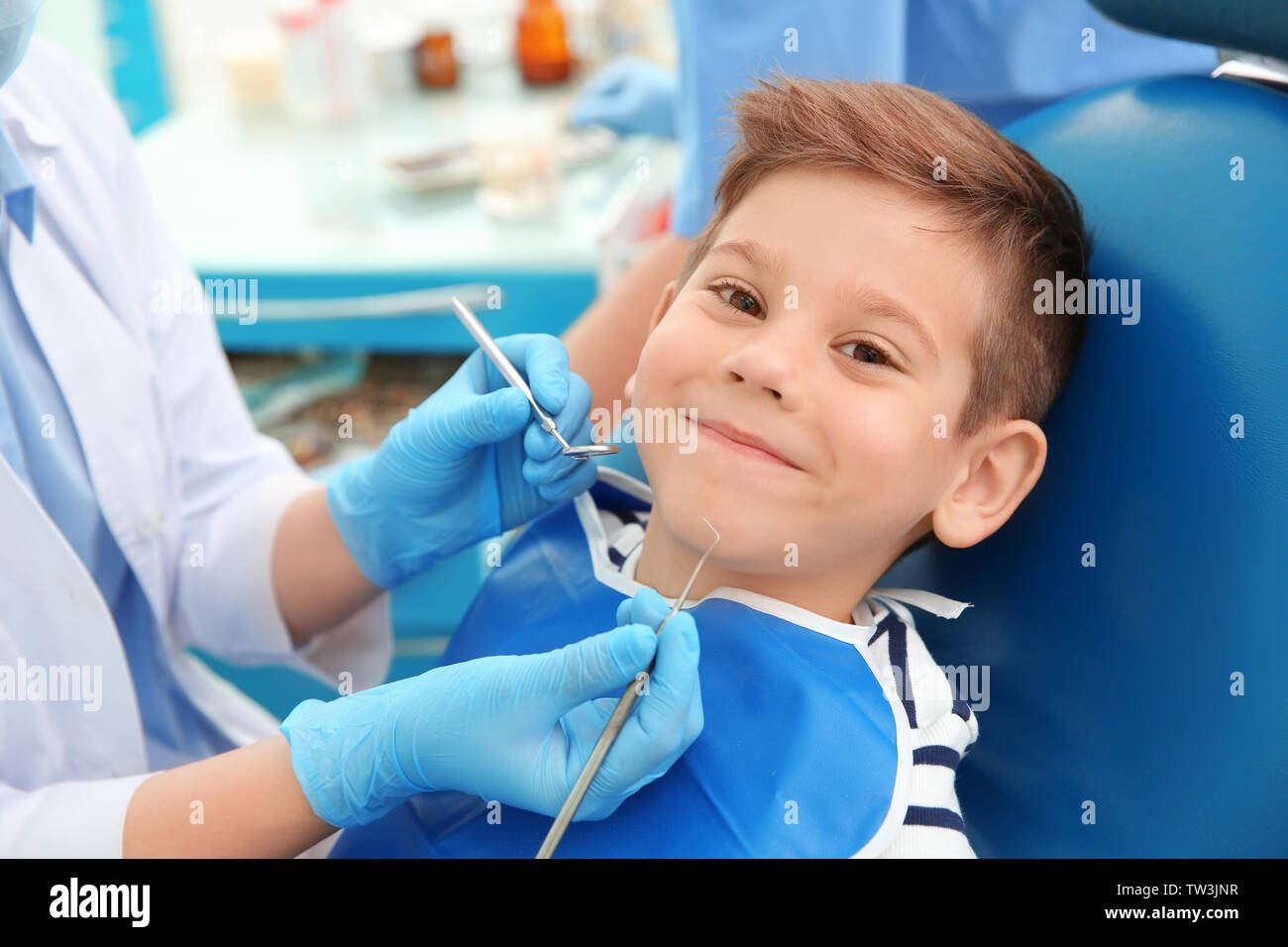 Dentist examining little boy's teeth in clinic Stock Photo - Alamy