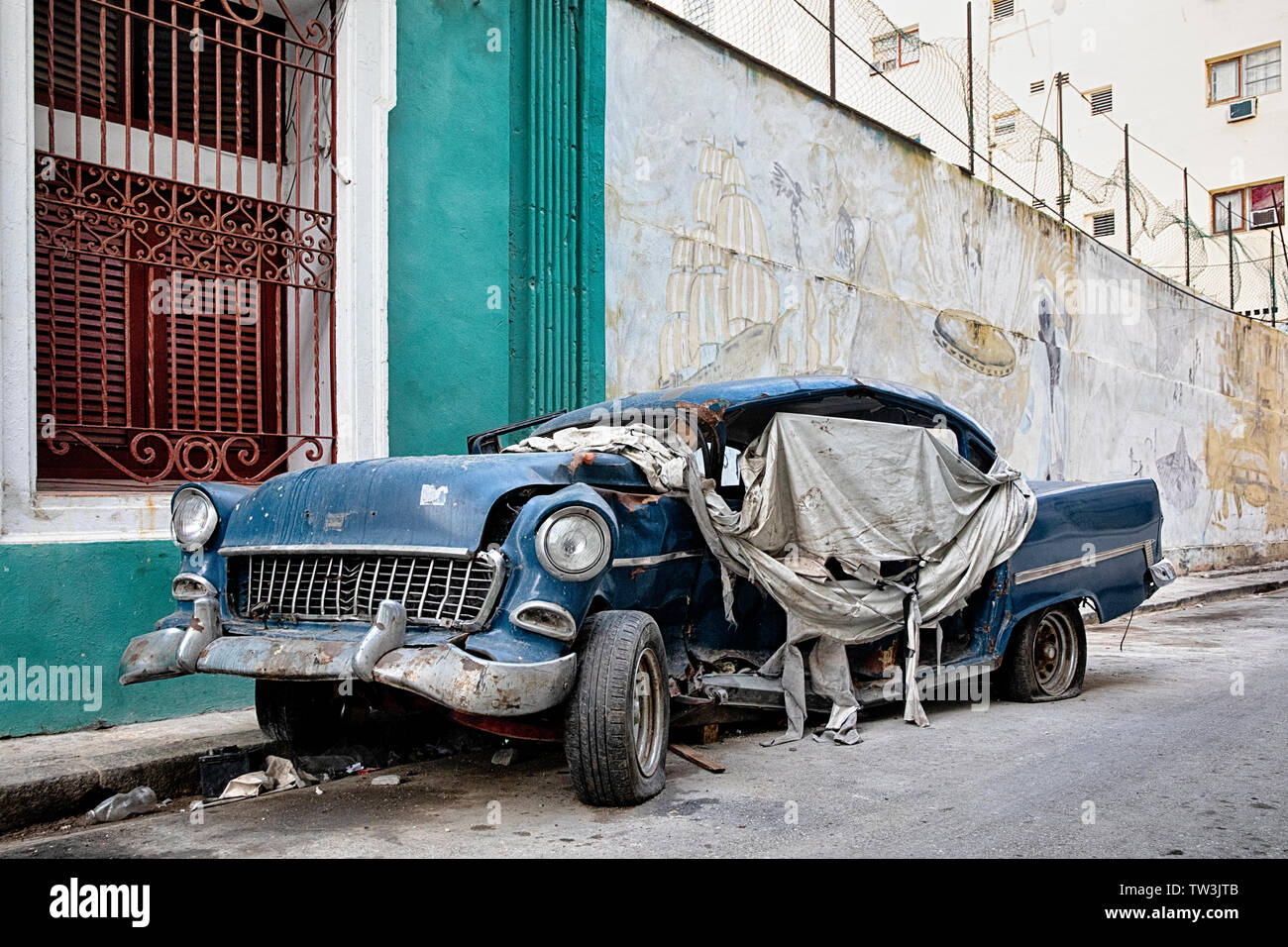 A wrecked and ruined old American car parked in the back streets of ...