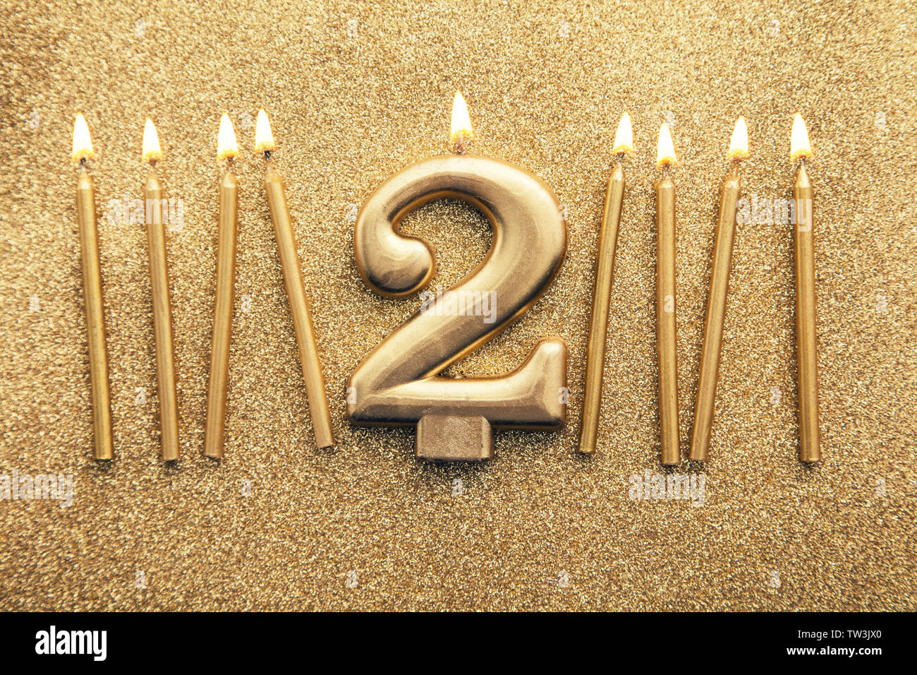 Number 2 gold celebration candle on a glitter background Stock Photo ...