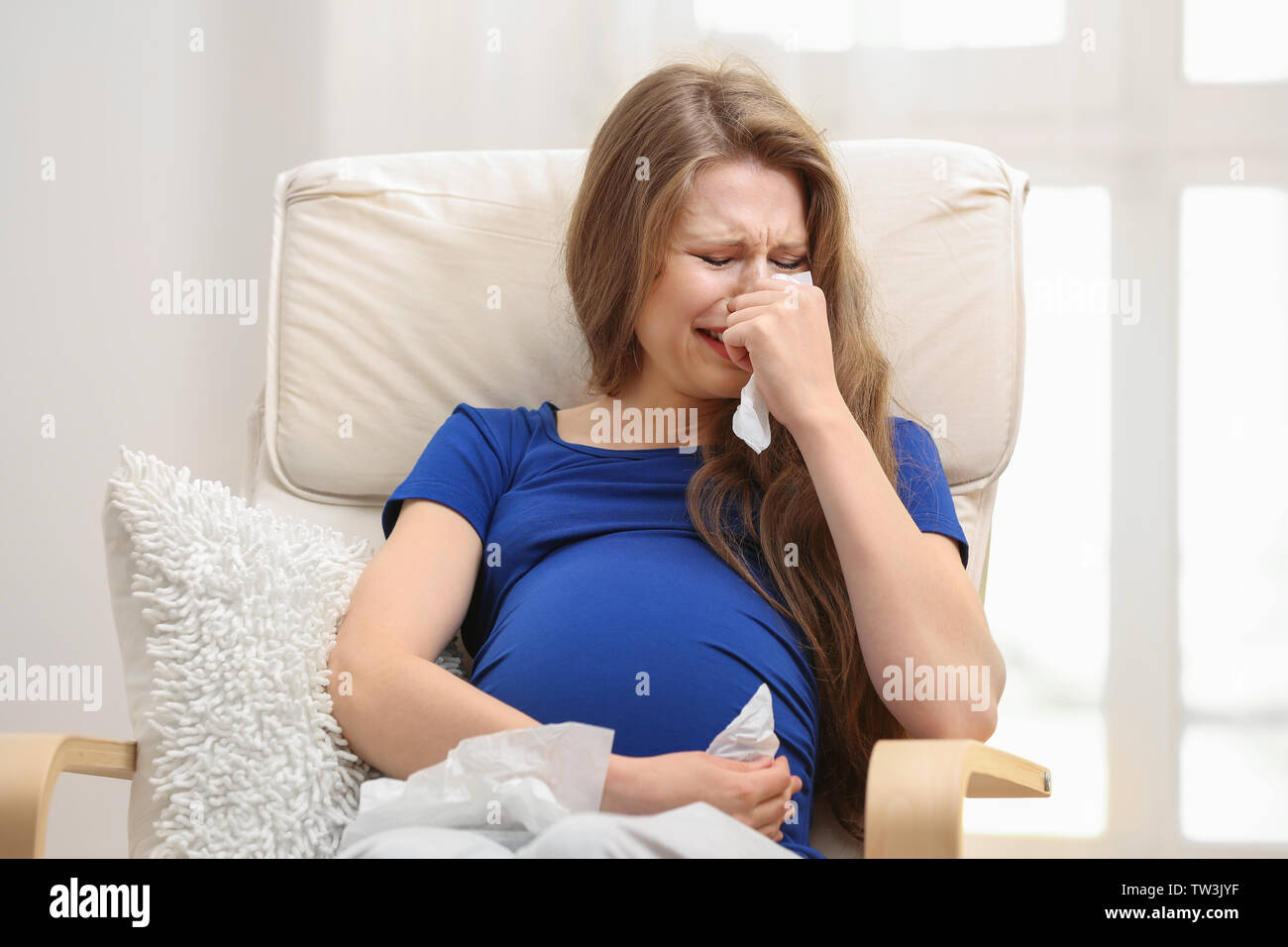 Emotional pregnant woman sitting in arm chair and crying. Pregnancy ...