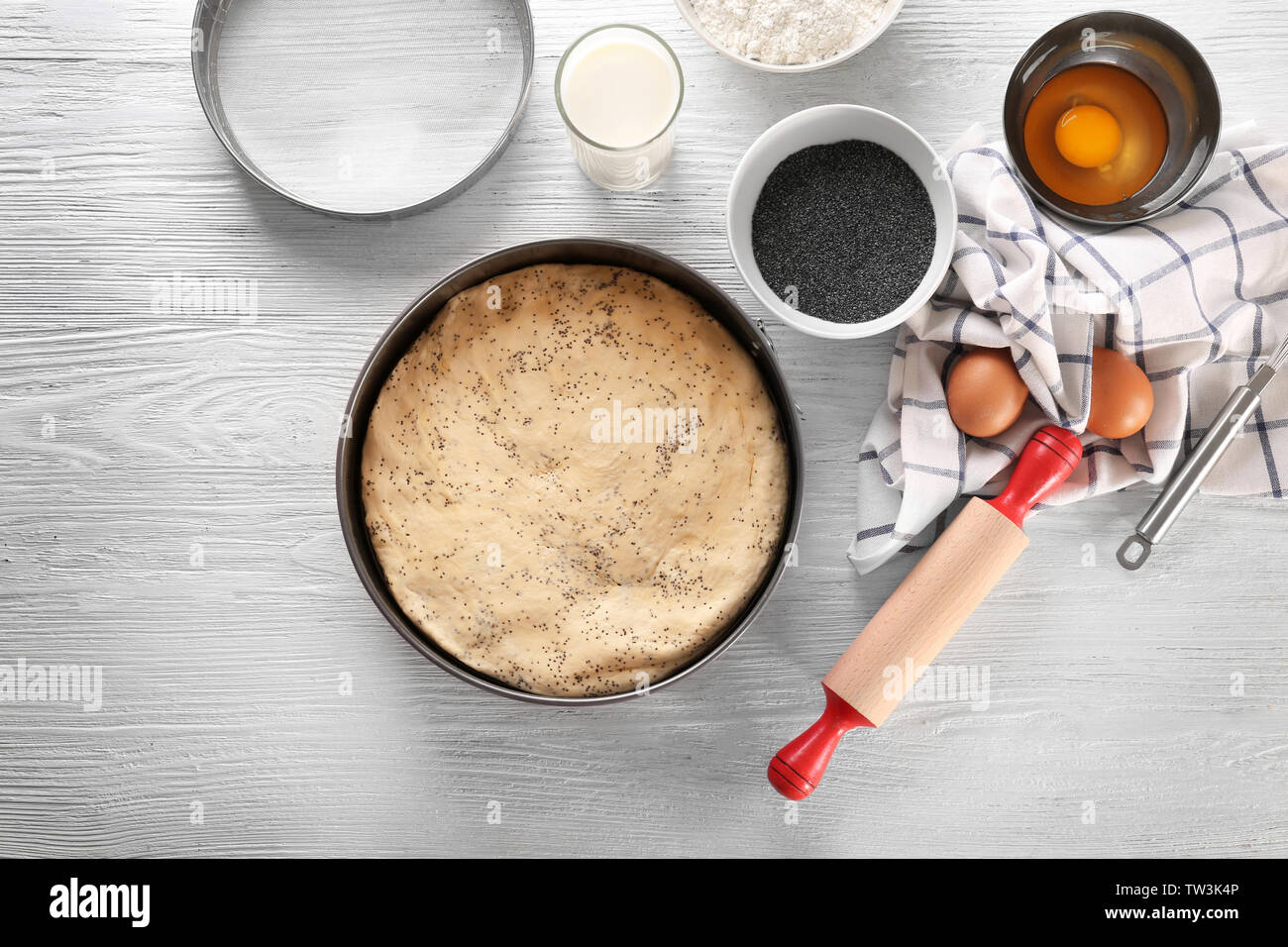 Baking form with raw dough and ingredients on kitchen table Stock Photo ...