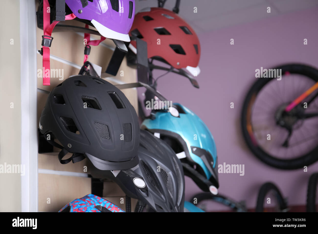 Stand with new modern bicycle helmets in shop Stock Photo - Alamy