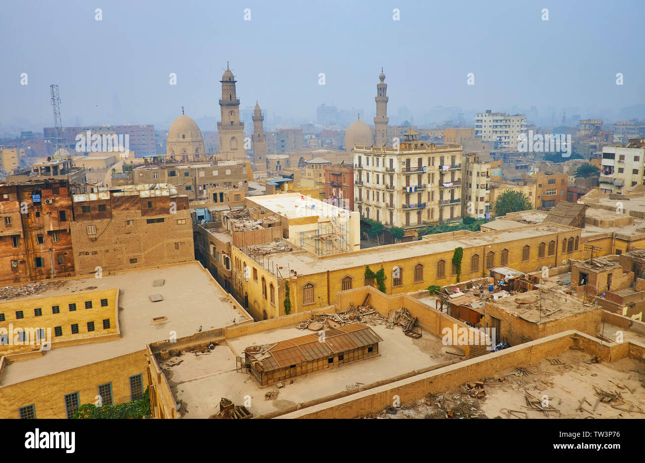 The shabby roofs of Islamic Cairo neighborhood in heavy winter haze ...
