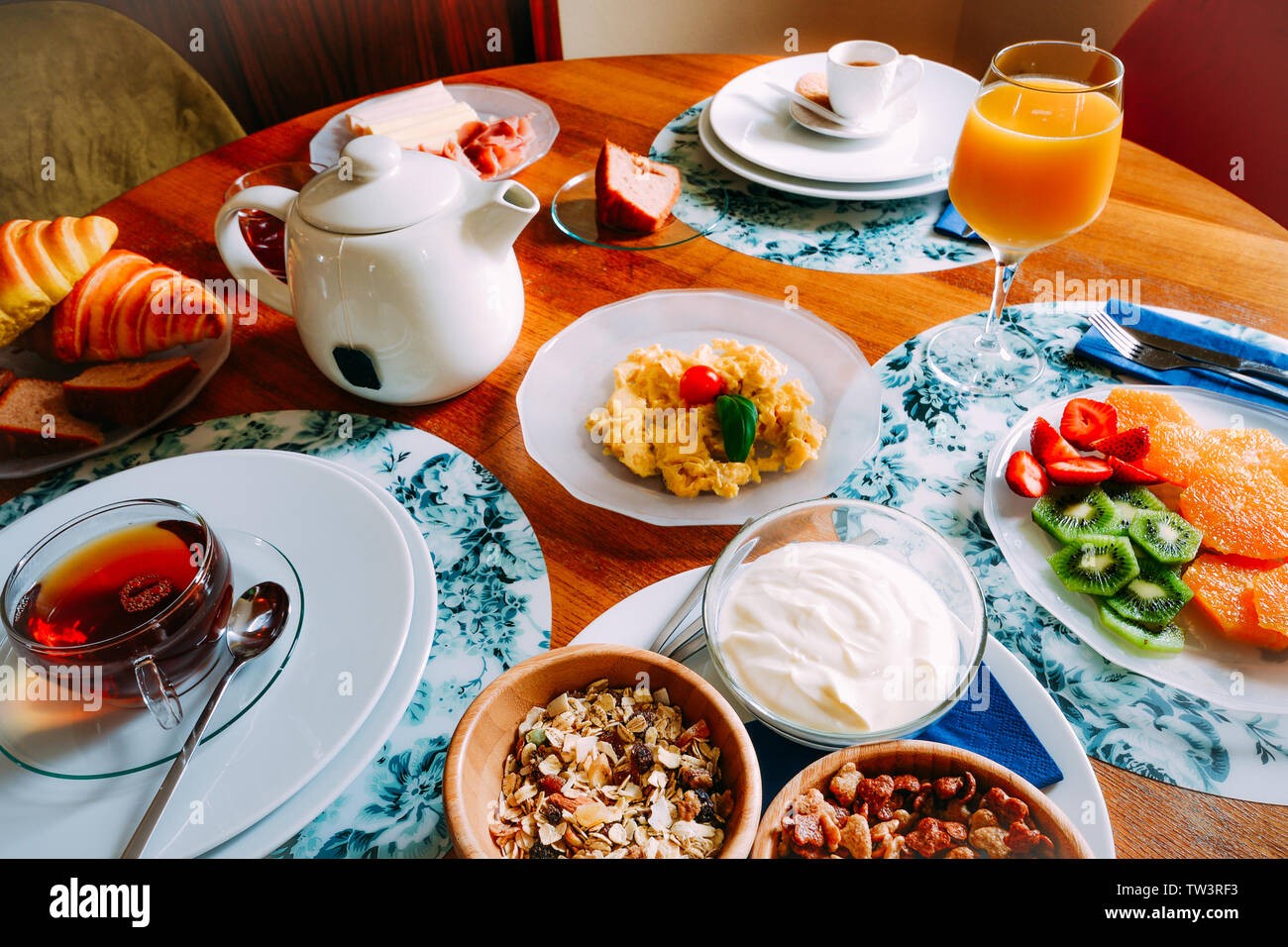 Breakfast table with variety of foods including cereals, yoghurt ...