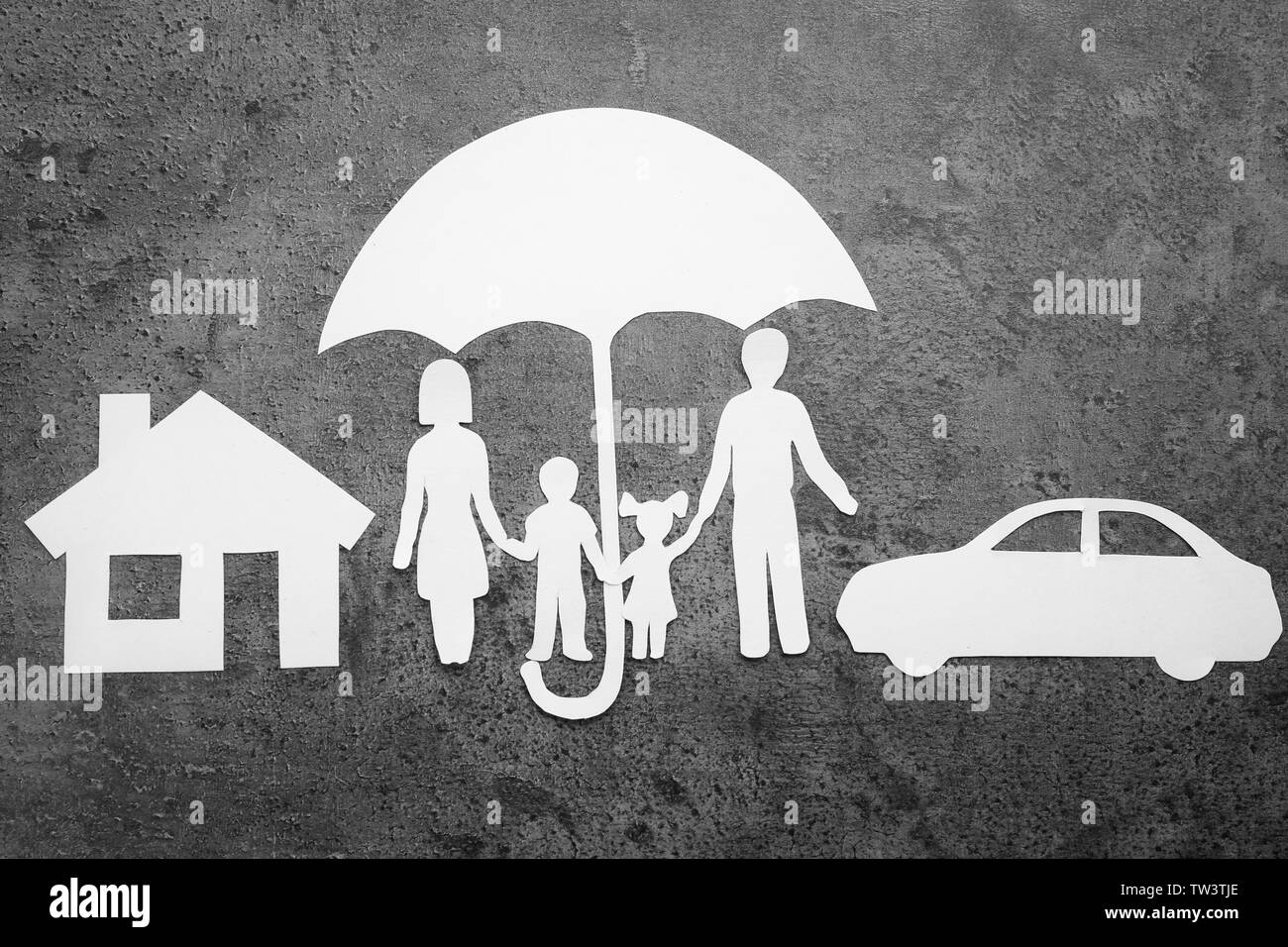 Paper silhouette of family under umbrella, house and car on grey ...