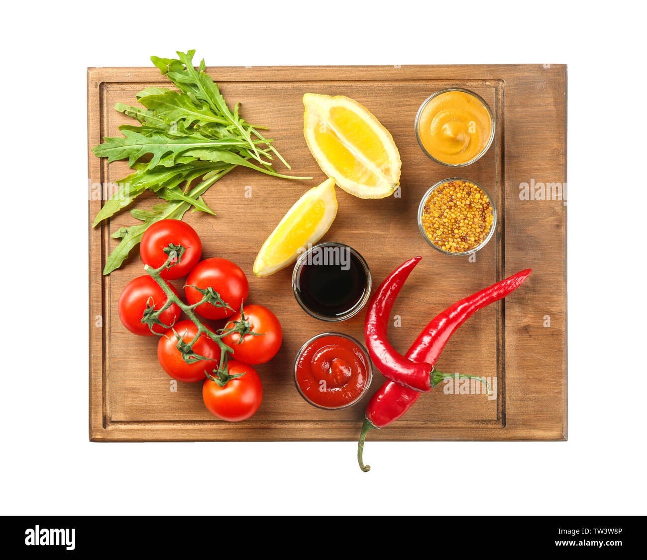 Wooden plate with different sauces and vegetables on white background ...
