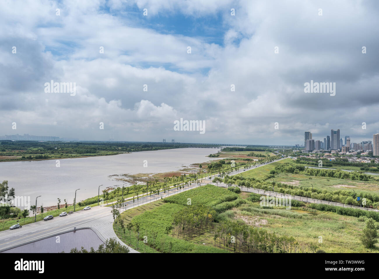 Cloudy weather overlooks riverside green space building Stock Photo - Alamy