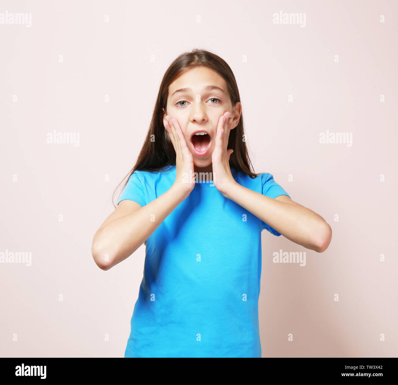 Cute surprised girl on color background Stock Photo - Alamy