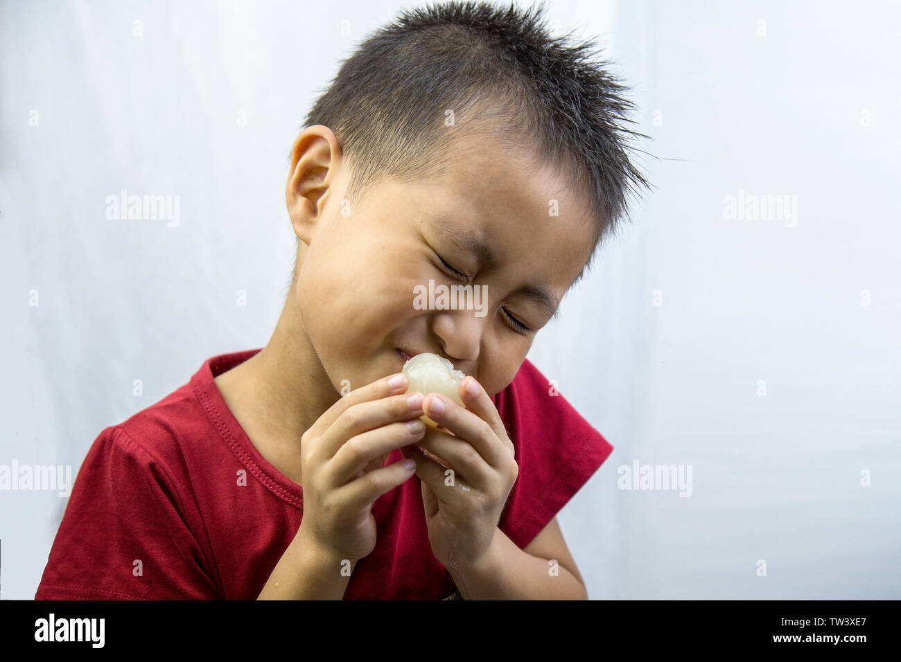 Boy eating lychee close-up Stock Photo - Alamy