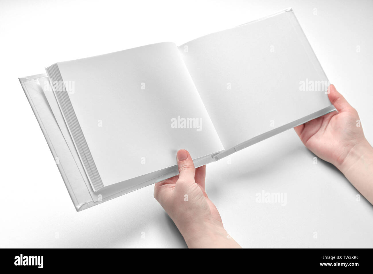 Female hands holding book with blank pages on white background Stock ...