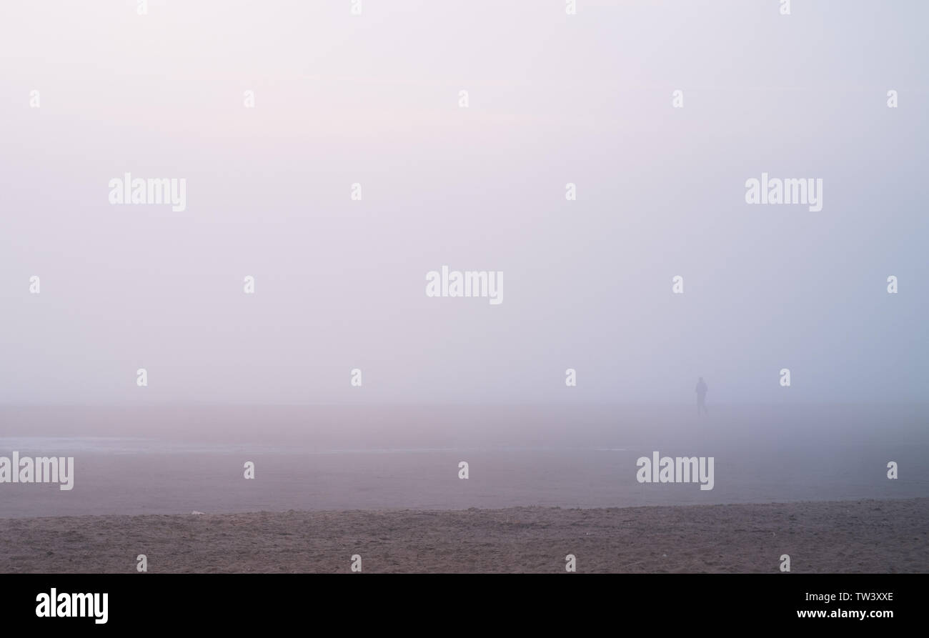 Foggy misty sunset, man walking in mist Stock Photo - Alamy
