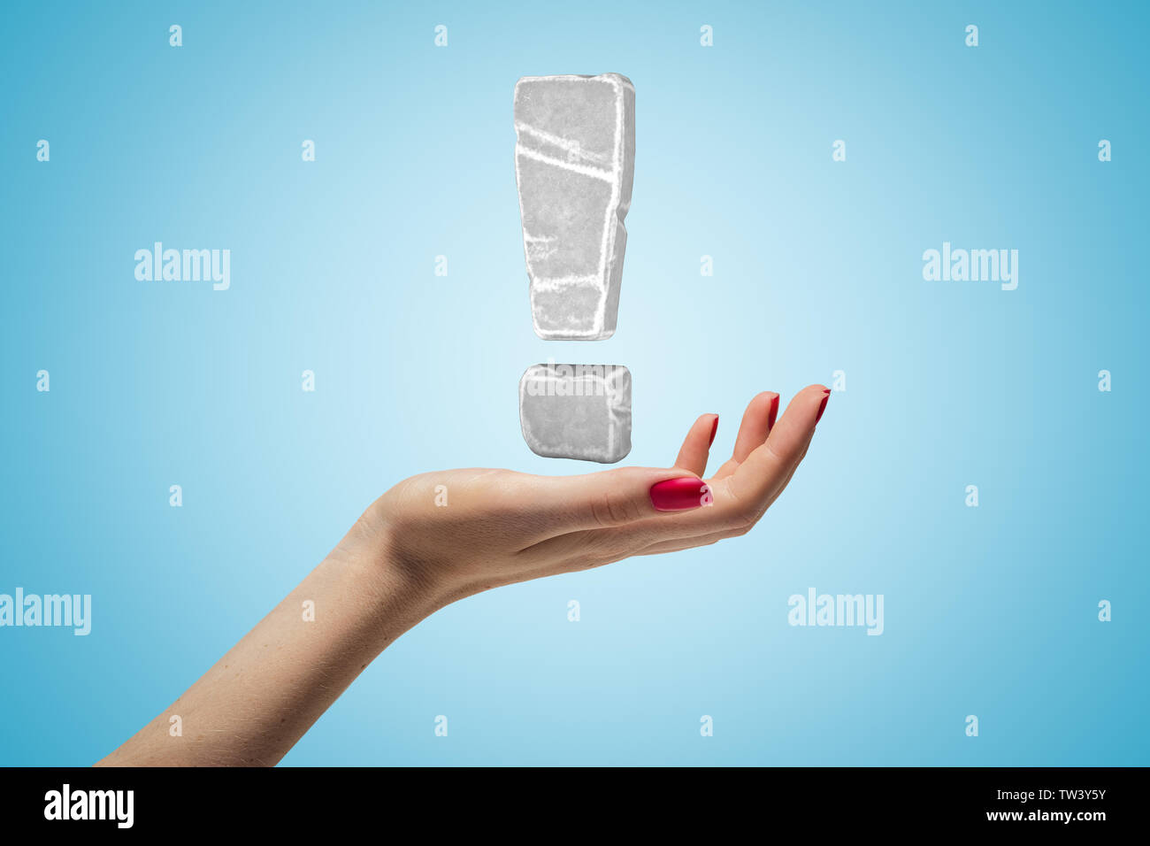 Female hand with grey concrete exclamation mark above on blue ...