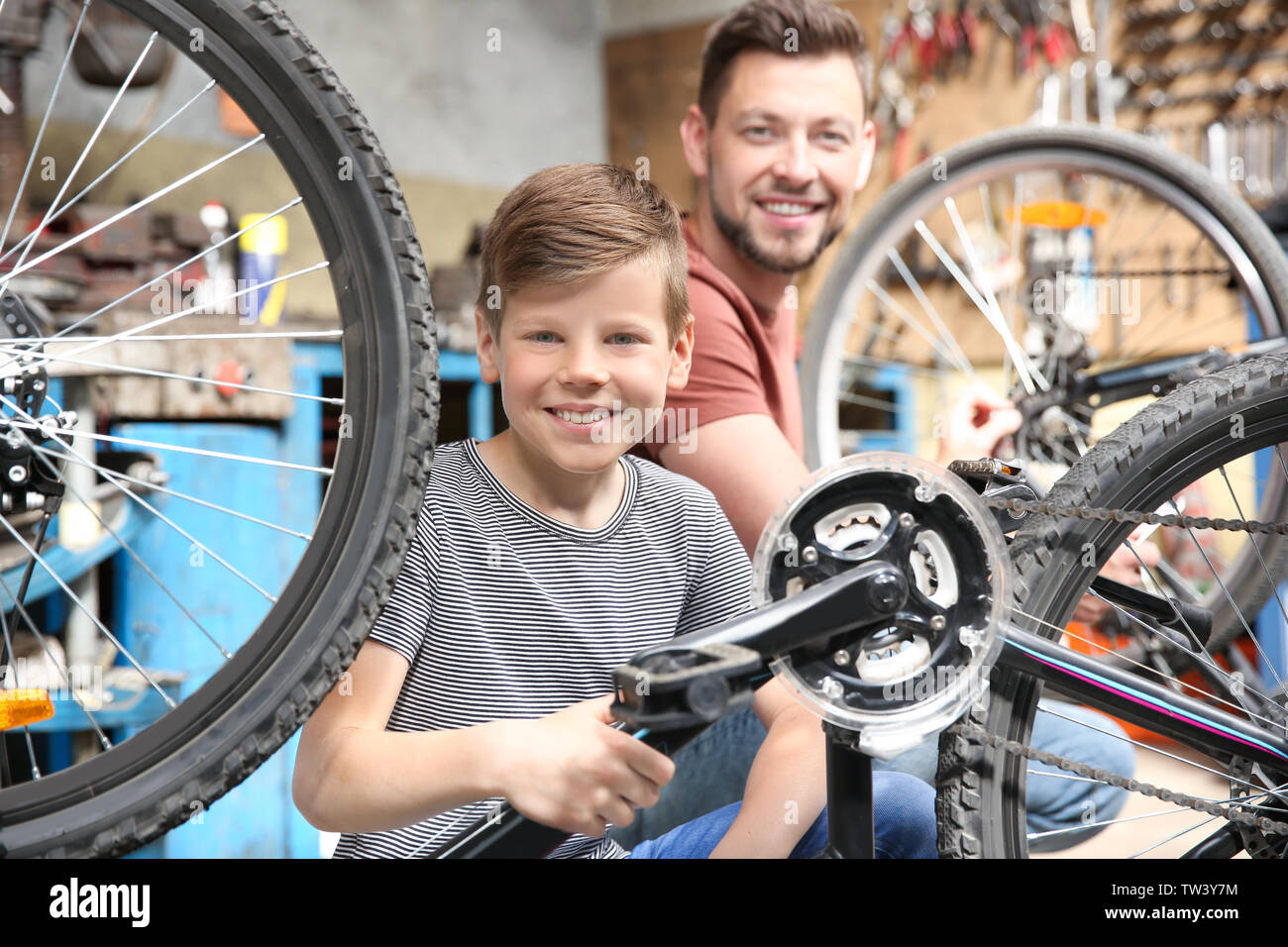 Dad and son fixing bicycles in garage Stock Photo - Alamy