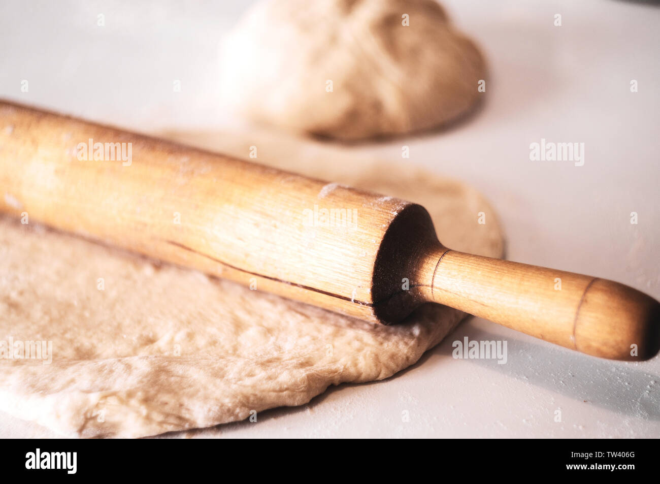 Classic wooden rolling pin with freshly prepared dough and dusting of ...