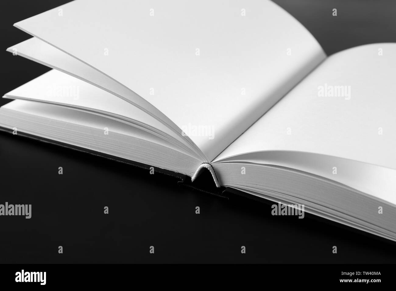 Open book with blank pages on black background Stock Photo - Alamy