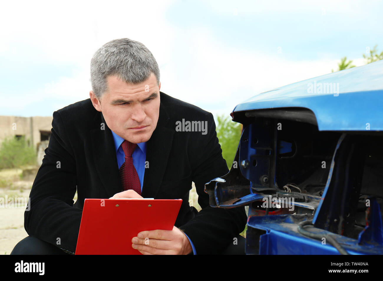 Insurance man checking broken car after accident Stock Photo - Alamy