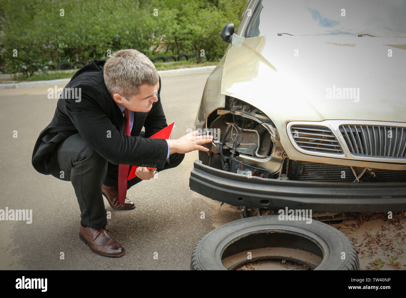 Insurance man checking broken car after accident Stock Photo - Alamy