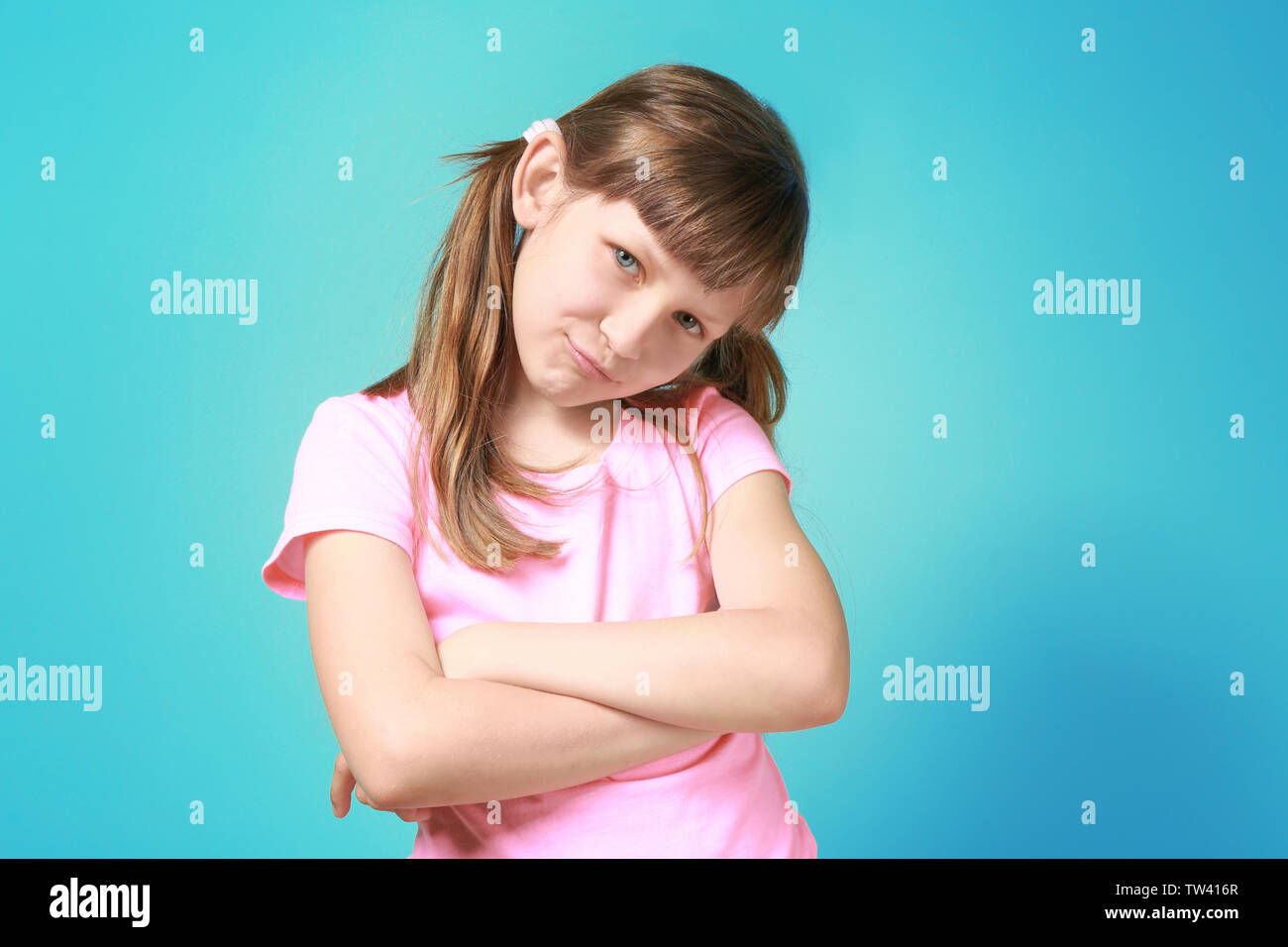 Displeased little girl on color background Stock Photo - Alamy