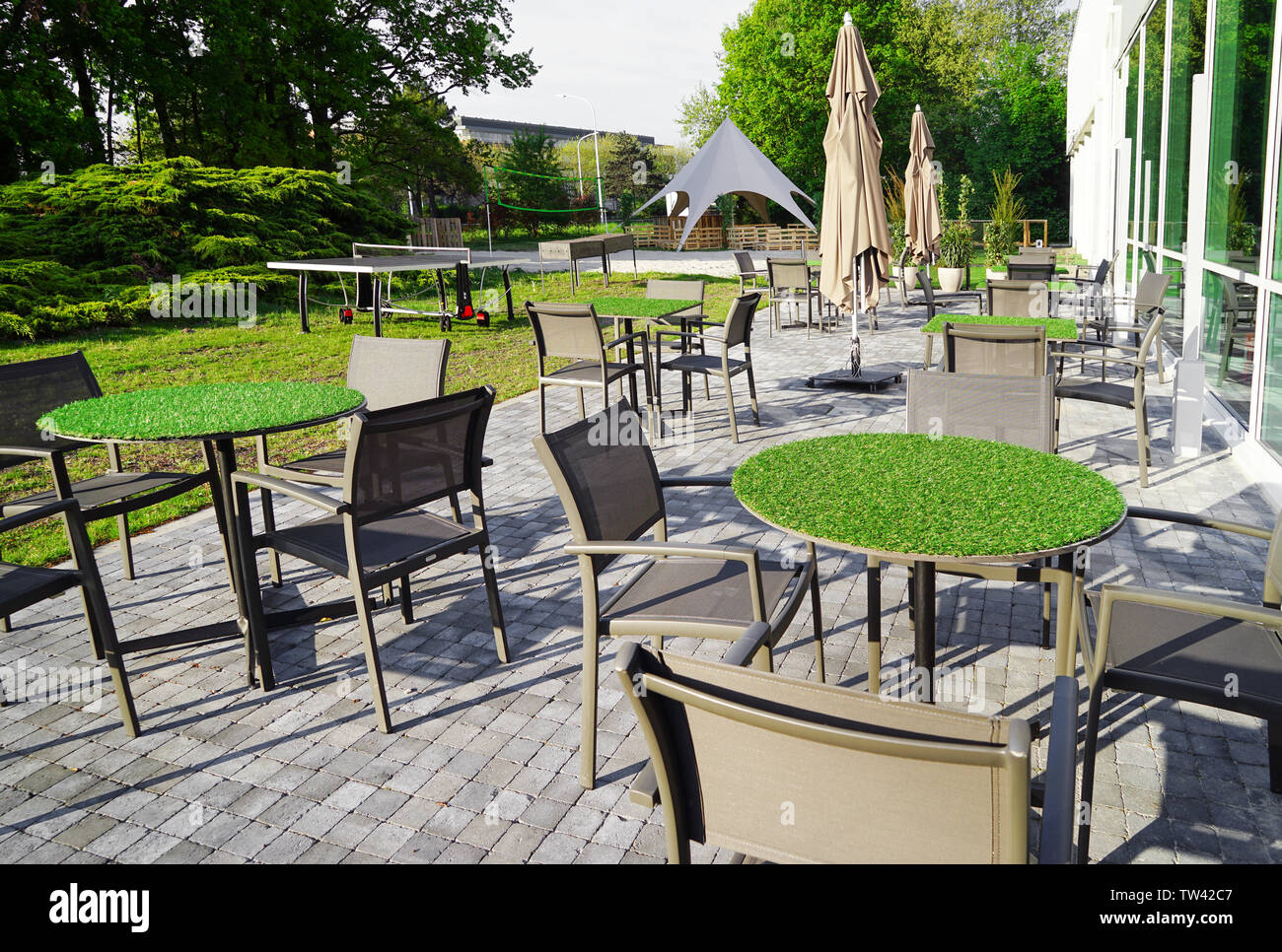 Modern cafe with creative tables on sunny day Stock Photo - Alamy