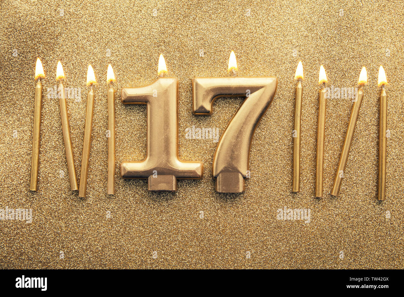 Number 17 gold celebration candle on a glitter background Stock Photo ...