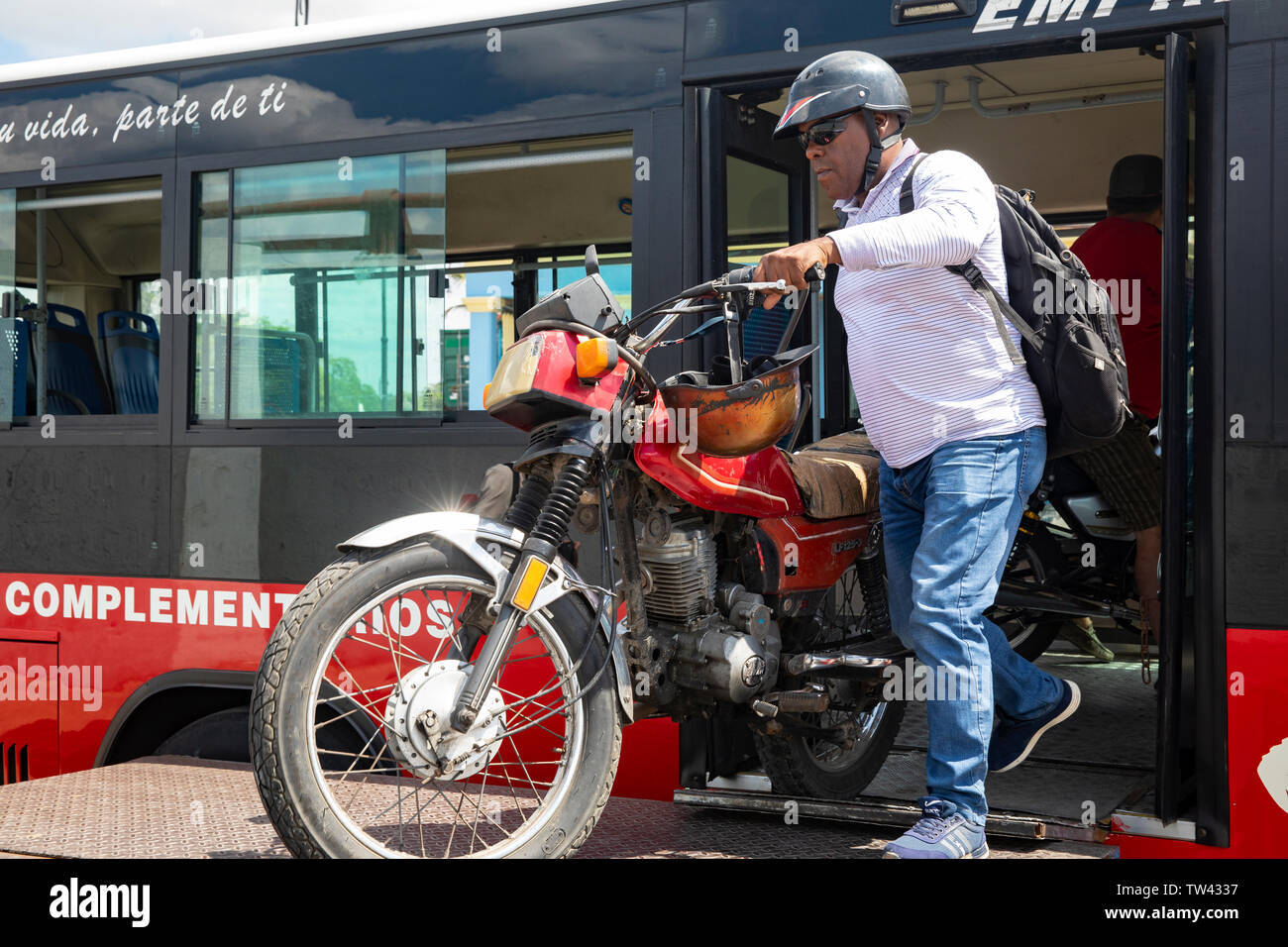 Cuban guys taking there motorbikes of a bus in Havana Stock Photo - Alamy