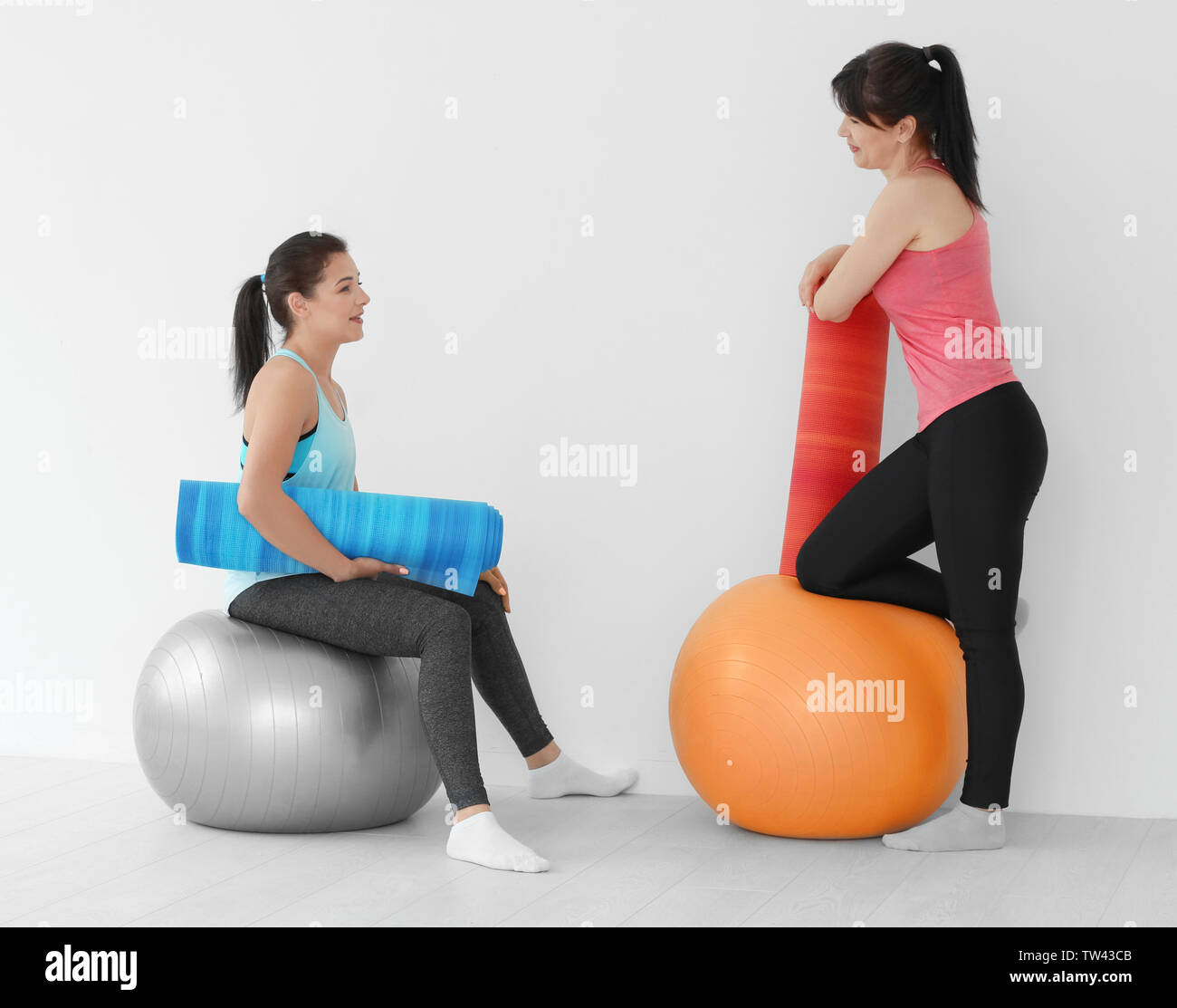 Women with stretch mats for practicing yoga in gym Stock Photo - Alamy