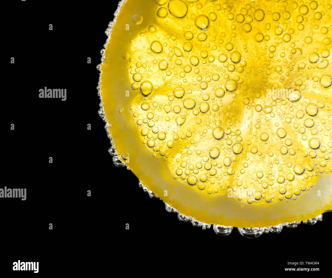 Lemon slice under water with bubbles on black background, close up ...