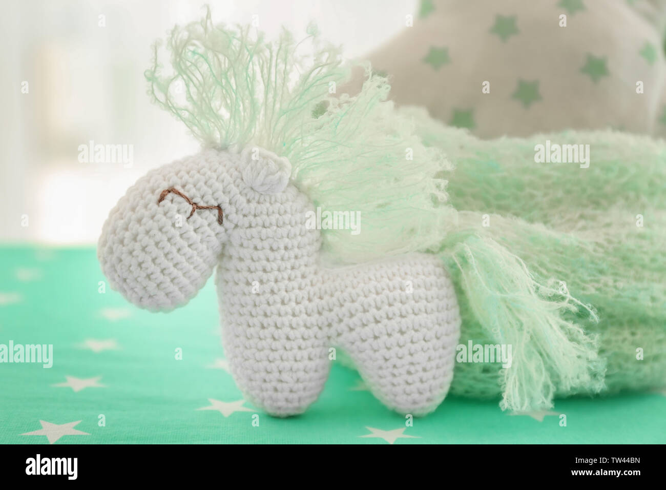 Cute baby toy on bed in room Stock Photo - Alamy