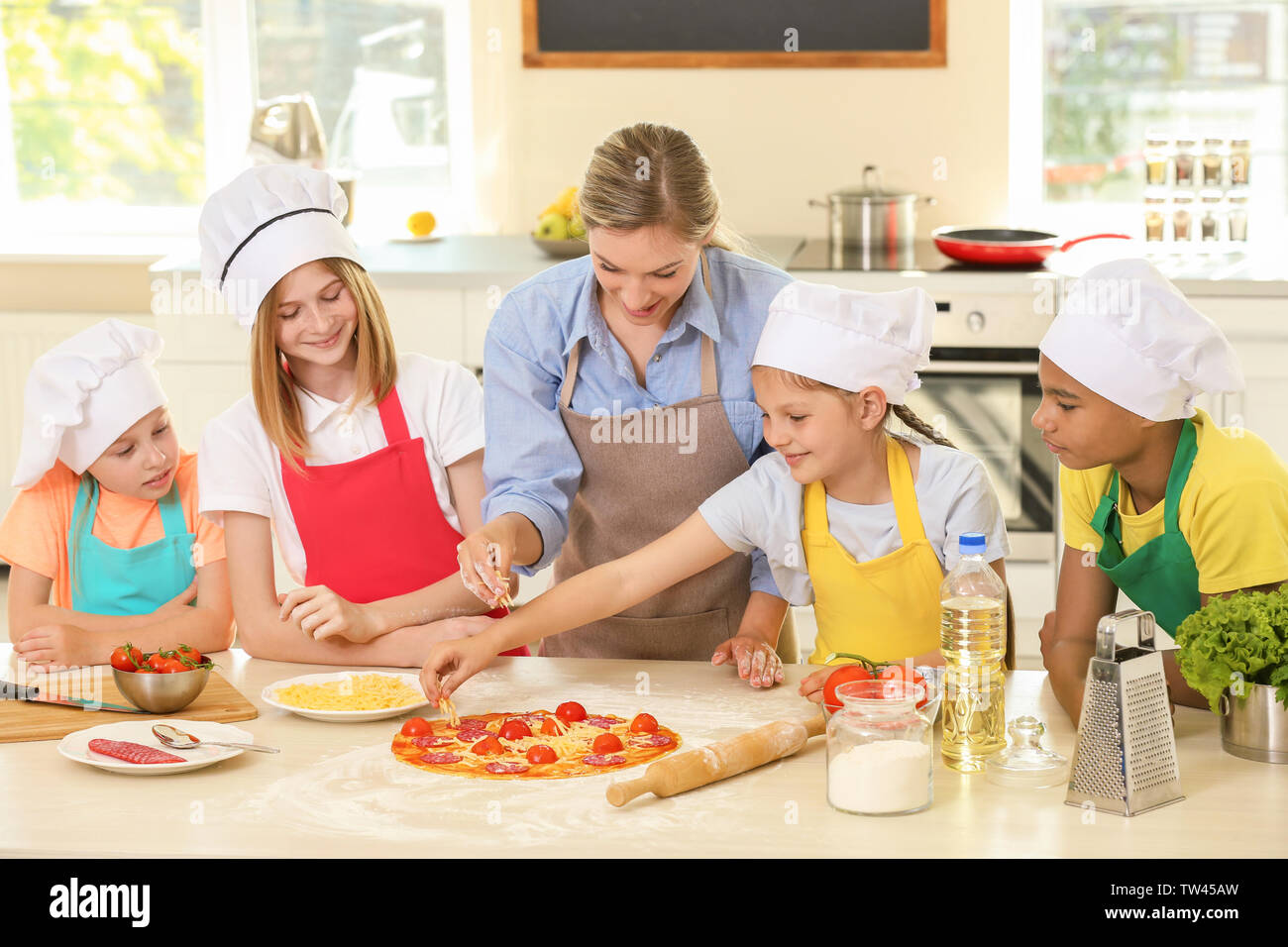 Group of children and teacher in kitchen during cooking classes Stock ...
