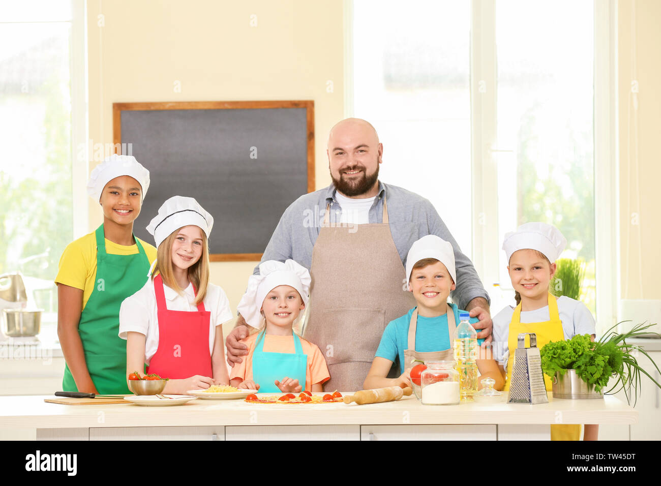 Group of children and teacher in kitchen during cooking classes Stock ...