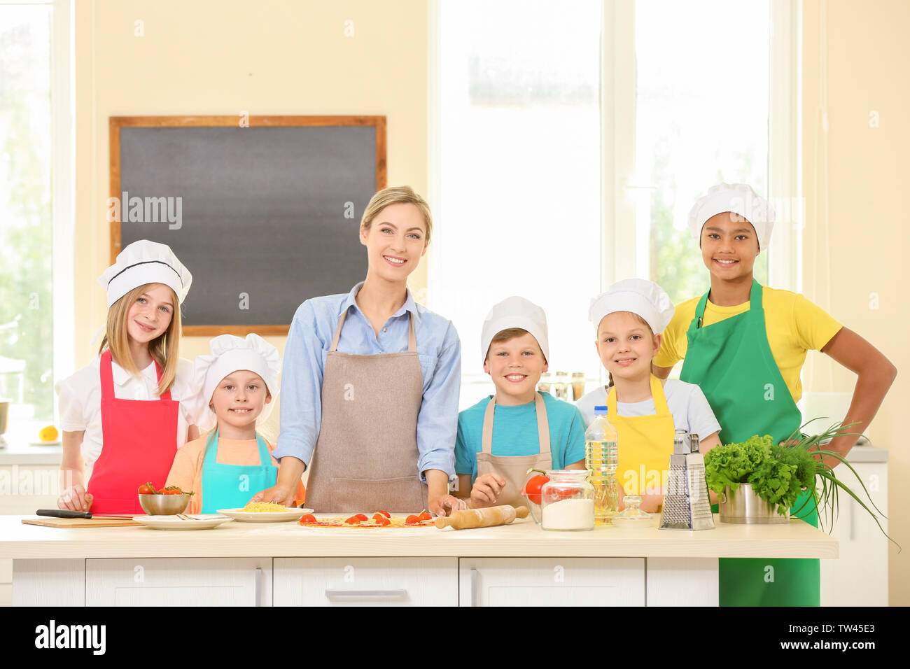 Group of children and teacher in kitchen during cooking classes Stock ...