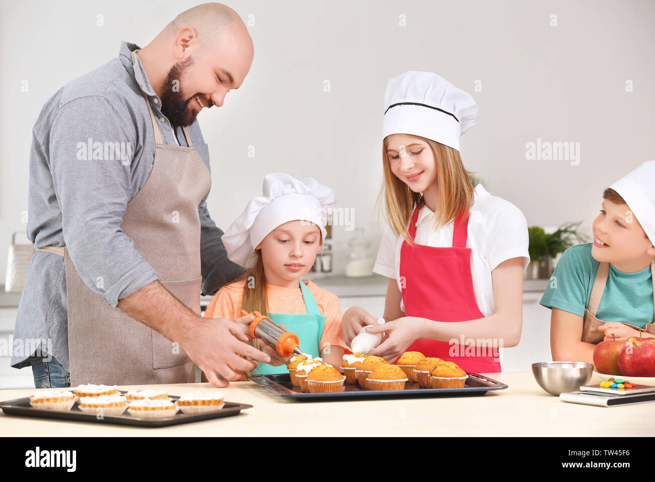 Group of children and teacher preparing dessert during cooking classes ...