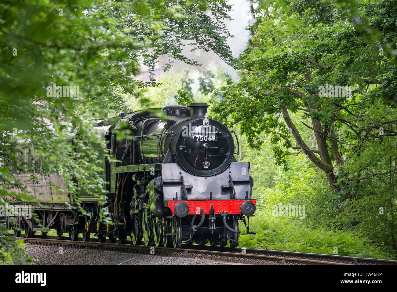 Close up of vintage UK steam train front, approaching, passing through ...