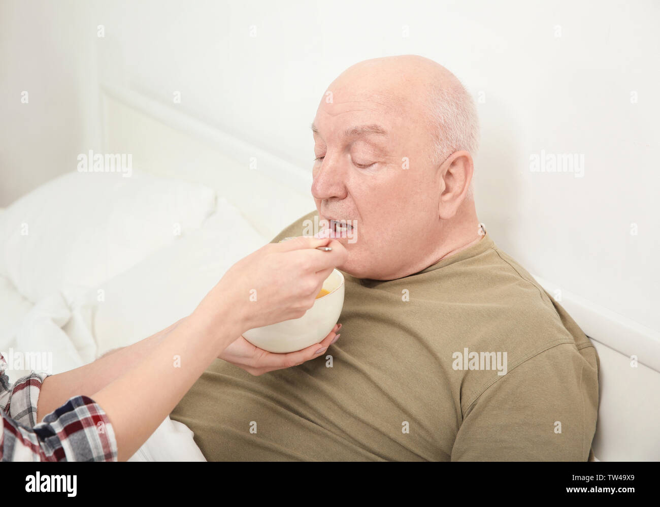 Spoon feeding elderly hi-res stock photography and images - Alamy