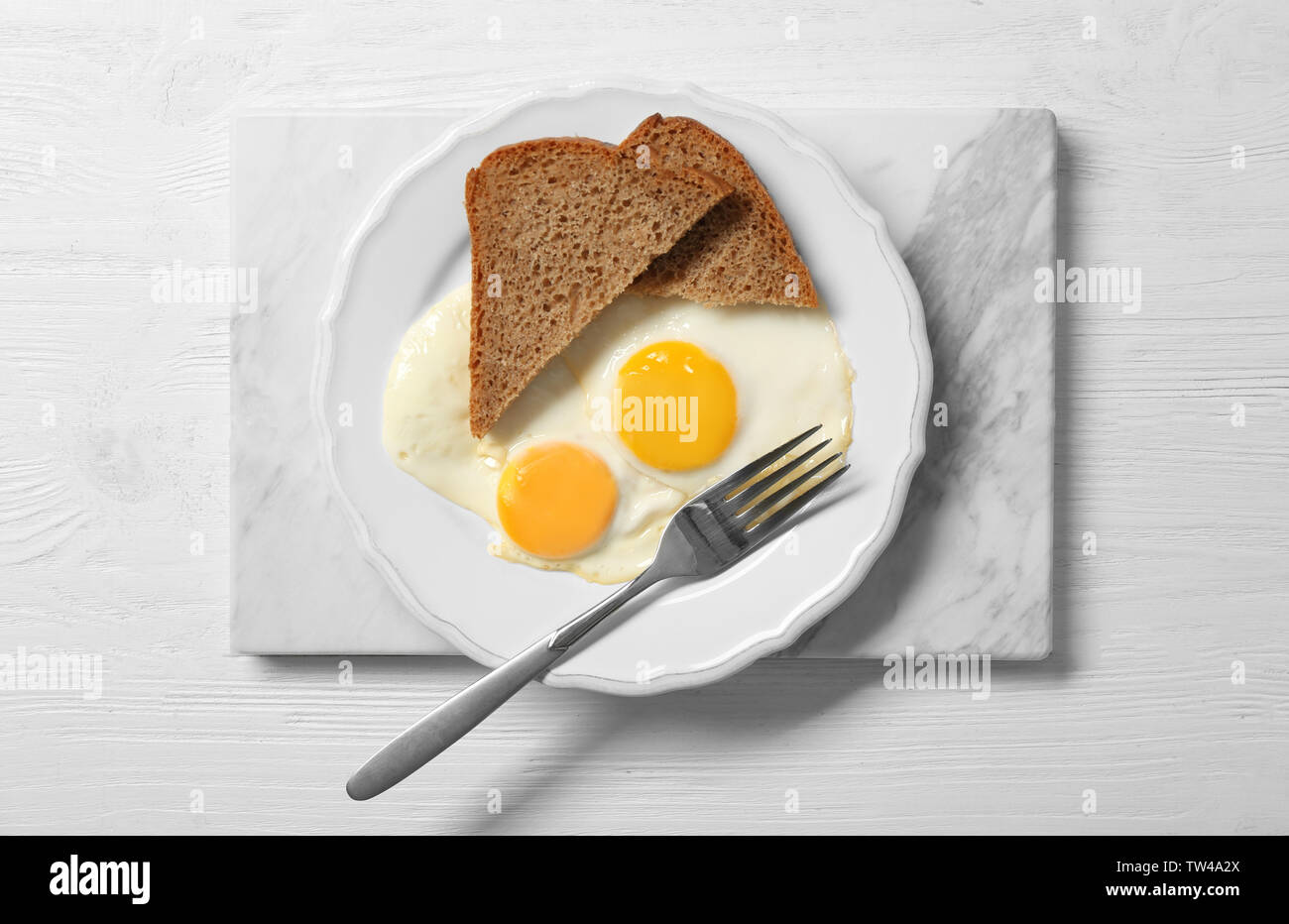 Delicious breakfast with over easy eggs on board Stock Photo - Alamy