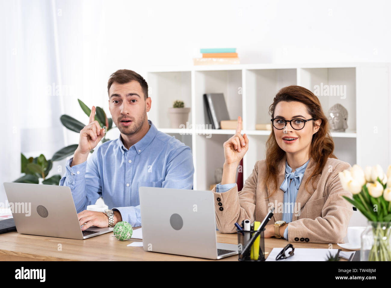 surprised woman sitting with coworker and gesturing in office Stock ...