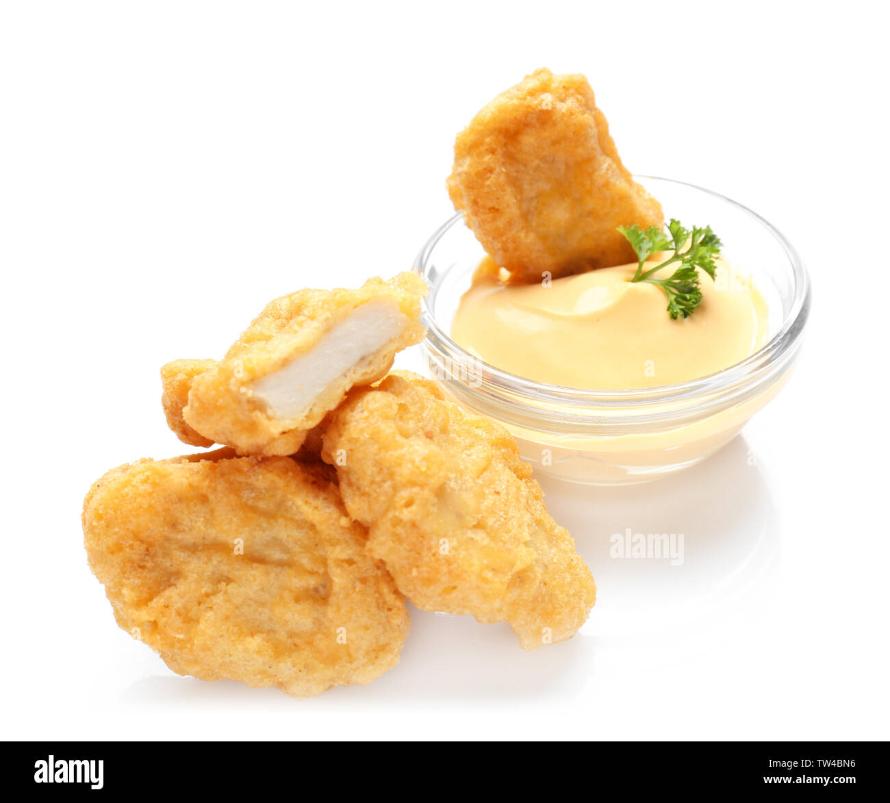 Tasty nuggets and small bowl with sauce for chicken on white background ...